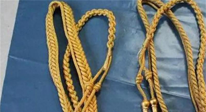 What is the "yellow rope" hanging on the military uniforms of various ...