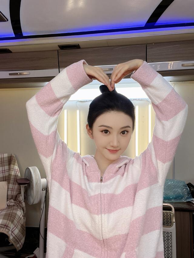 Jing Tian has changed a lot. She wears a pink striped knitted sweater ...