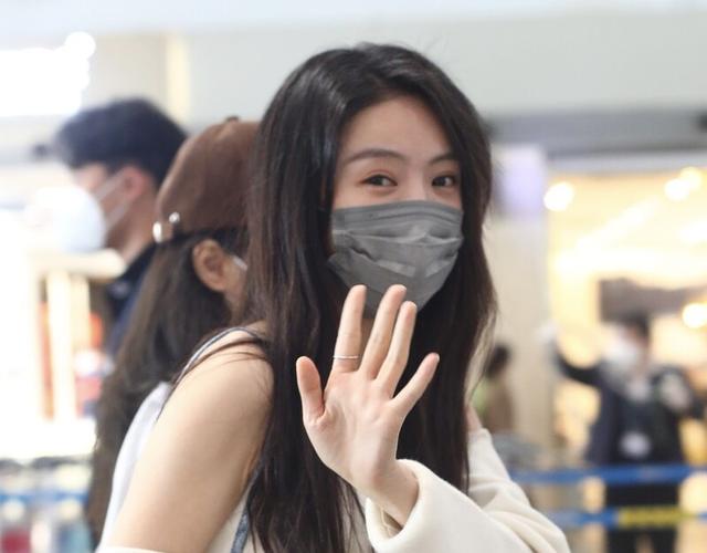 Cai Wenjing waved to fans at the airport wearing a tube top and jacket ...