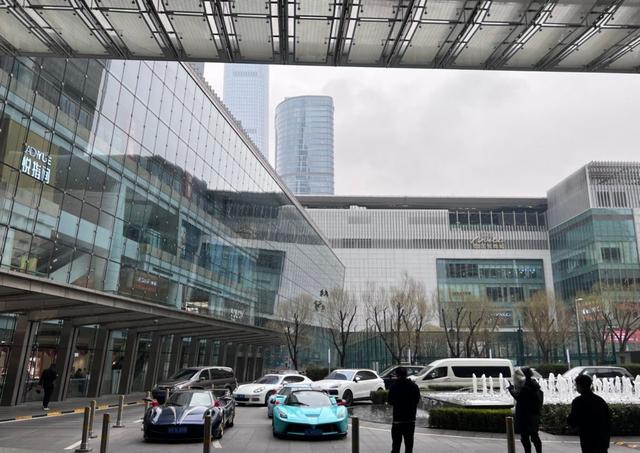 At the entrance of the China World Trade Center, three wedding cars are ...