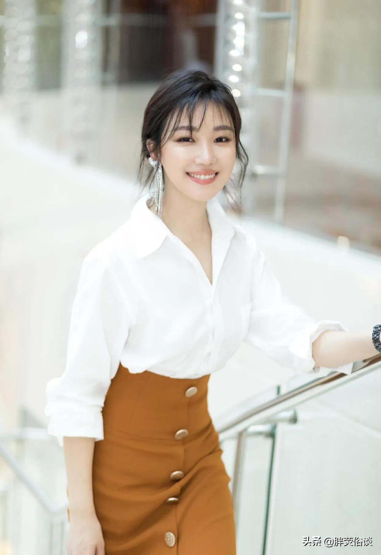 Jian Ren Zi is dressed in a simple white shirt and a brown skirt with a ...