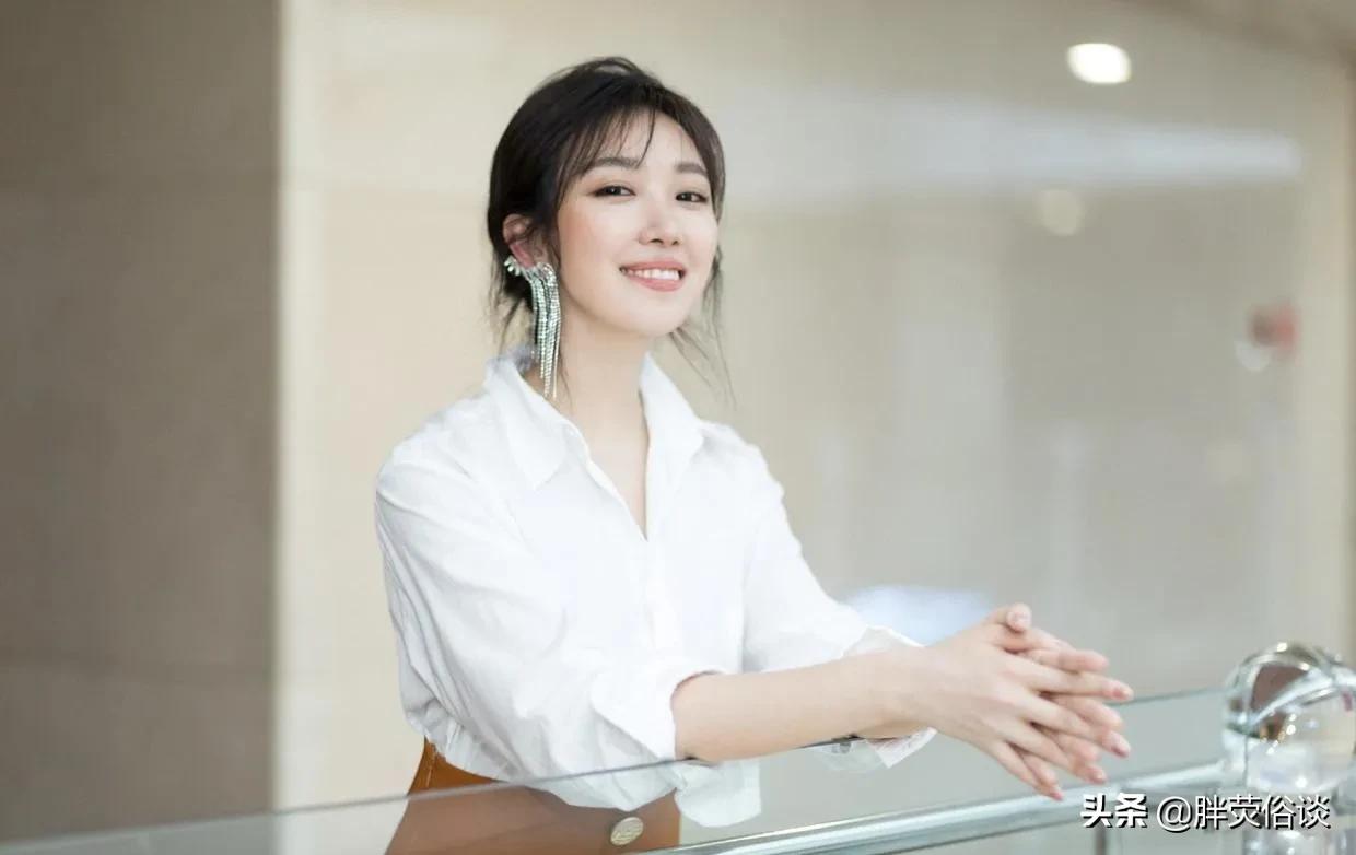 Jian Ren Zi is dressed in a simple white shirt and a brown skirt with a ...