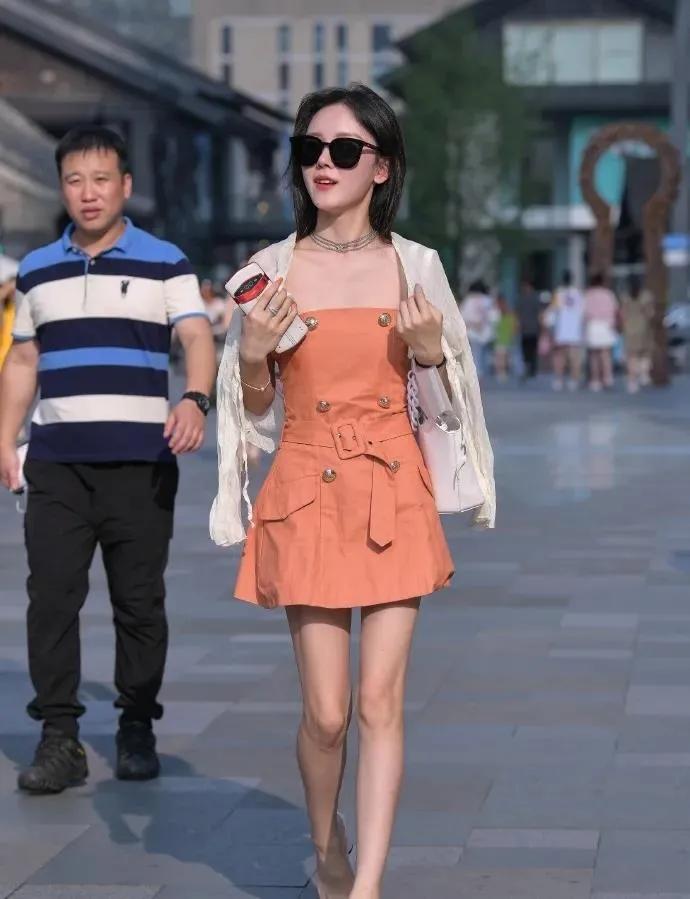 An orange button-decorated suspender skirt, with a tulle sun-protection ...