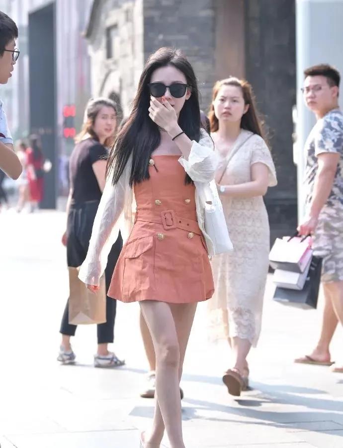 An orange button-decorated suspender skirt, with a tulle sun-protection ...