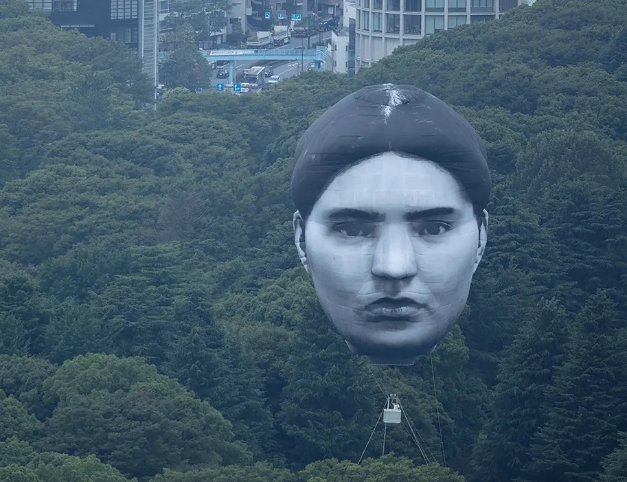 A giant "head balloon" floats over Tokyo with luminous light. Is this ...