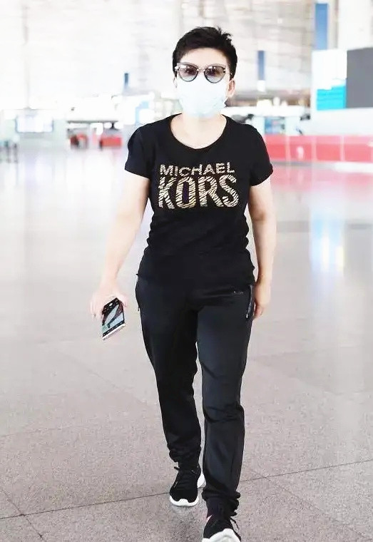 "Ping Pong Queen" Deng Yaping walks around the airport, wearing black ...