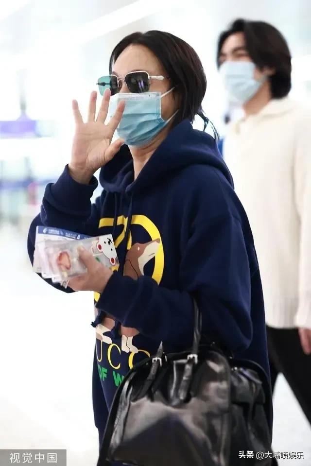 Huiying appeared at the airport in a red body casual hoodie, and waved ...