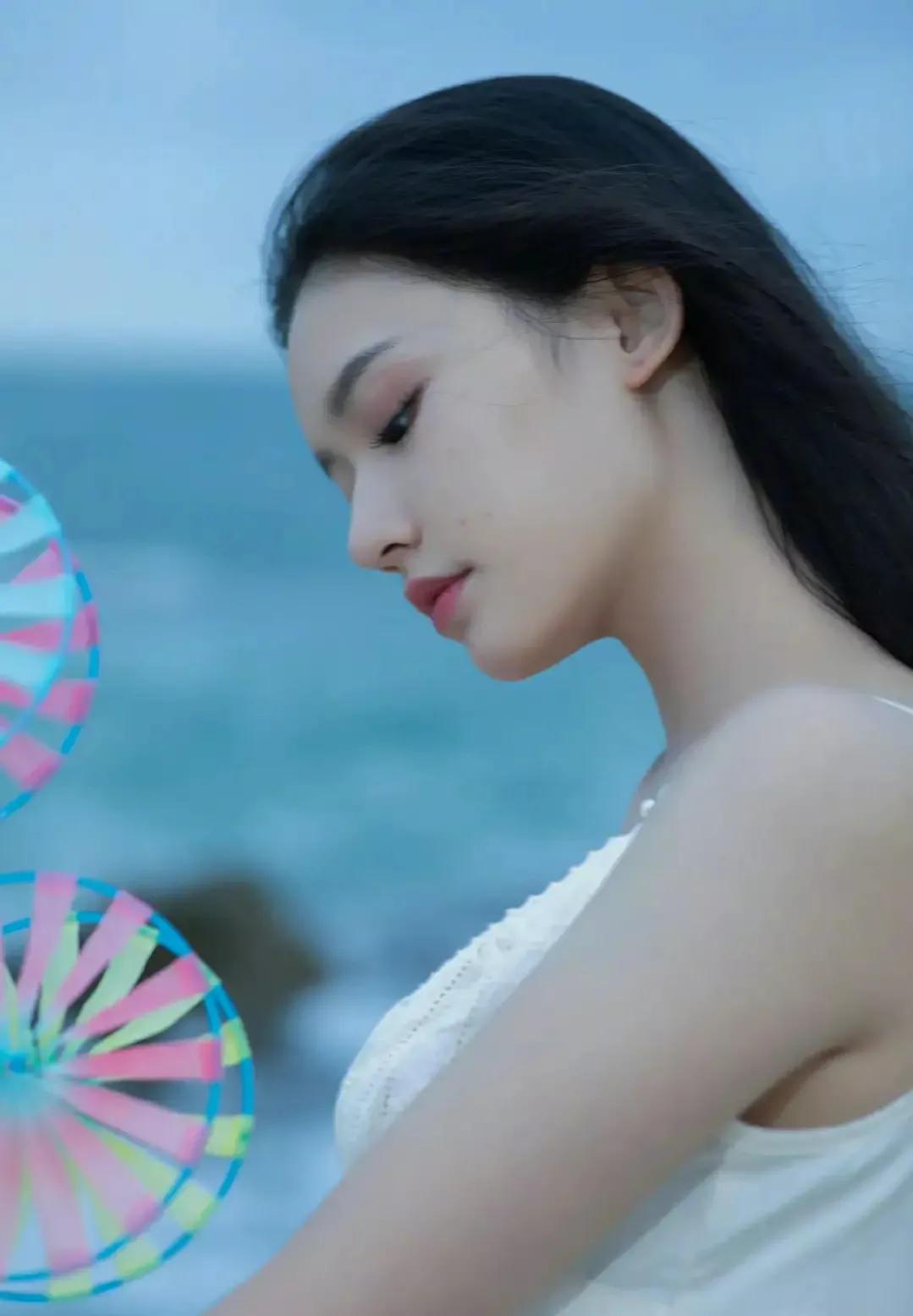 Lin Yun's beach photo by the sea, wearing a white dress with suspenders ...