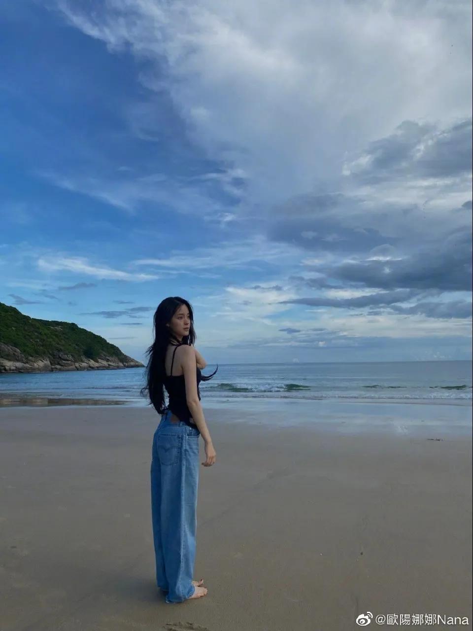 Ouyang Nana was wearing a black silk top with suspenders and loose wide-leg jeans, performing a ...