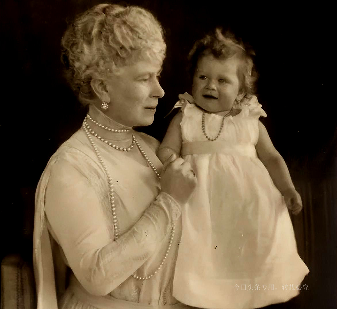 The 1-year-old queen is held in the arms of her grandmother Queen Mary ...