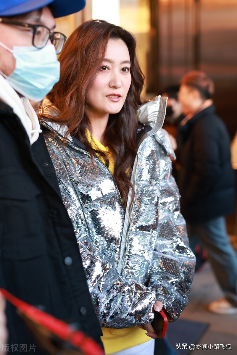 Tan Jing went out at the hotel, wearing a silver padded jacket in a ...