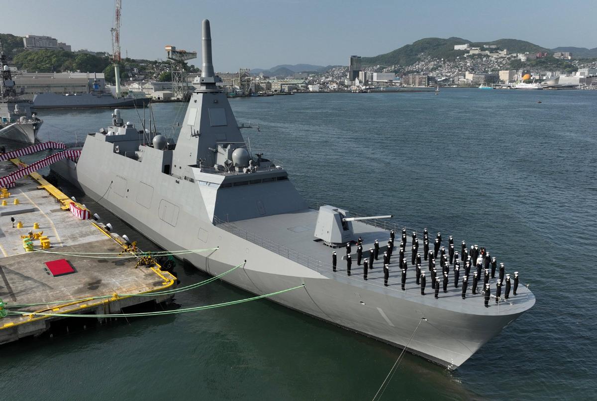 With a stick on his head, Japan looks down on the new frigate, and its ...