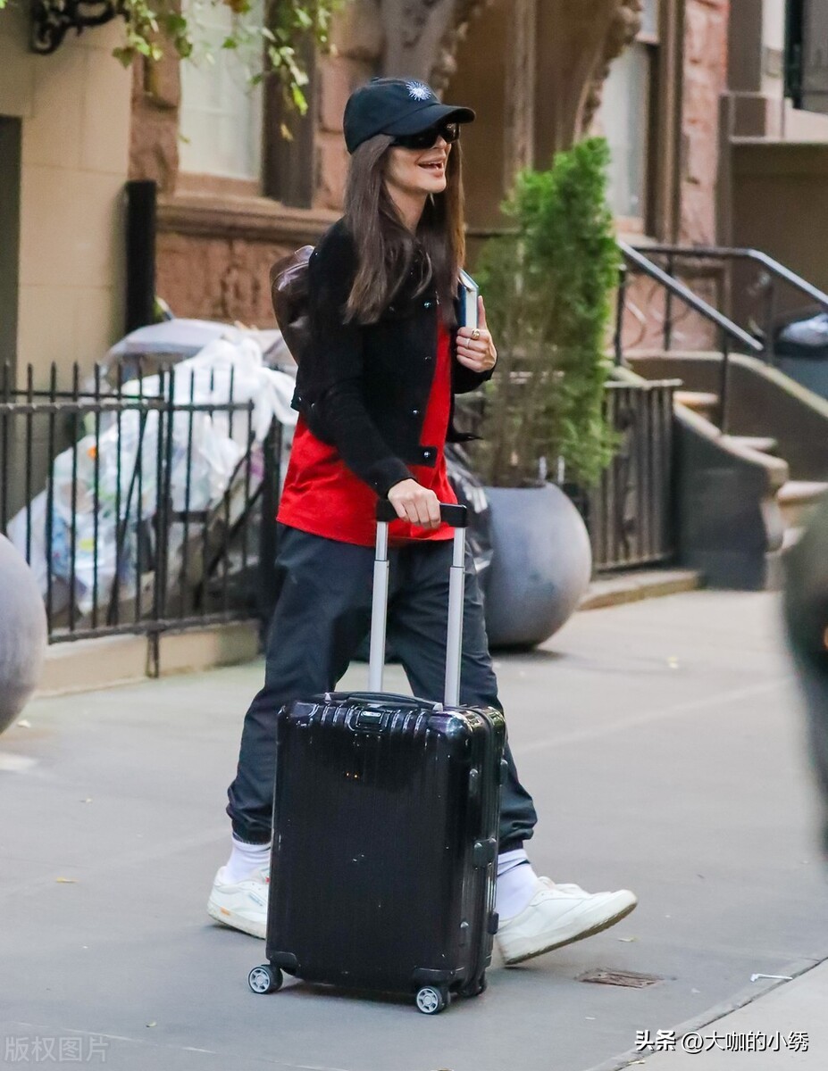 Emily Ratajkowski is wearing a black jacket + red T-shirt + baseball ...