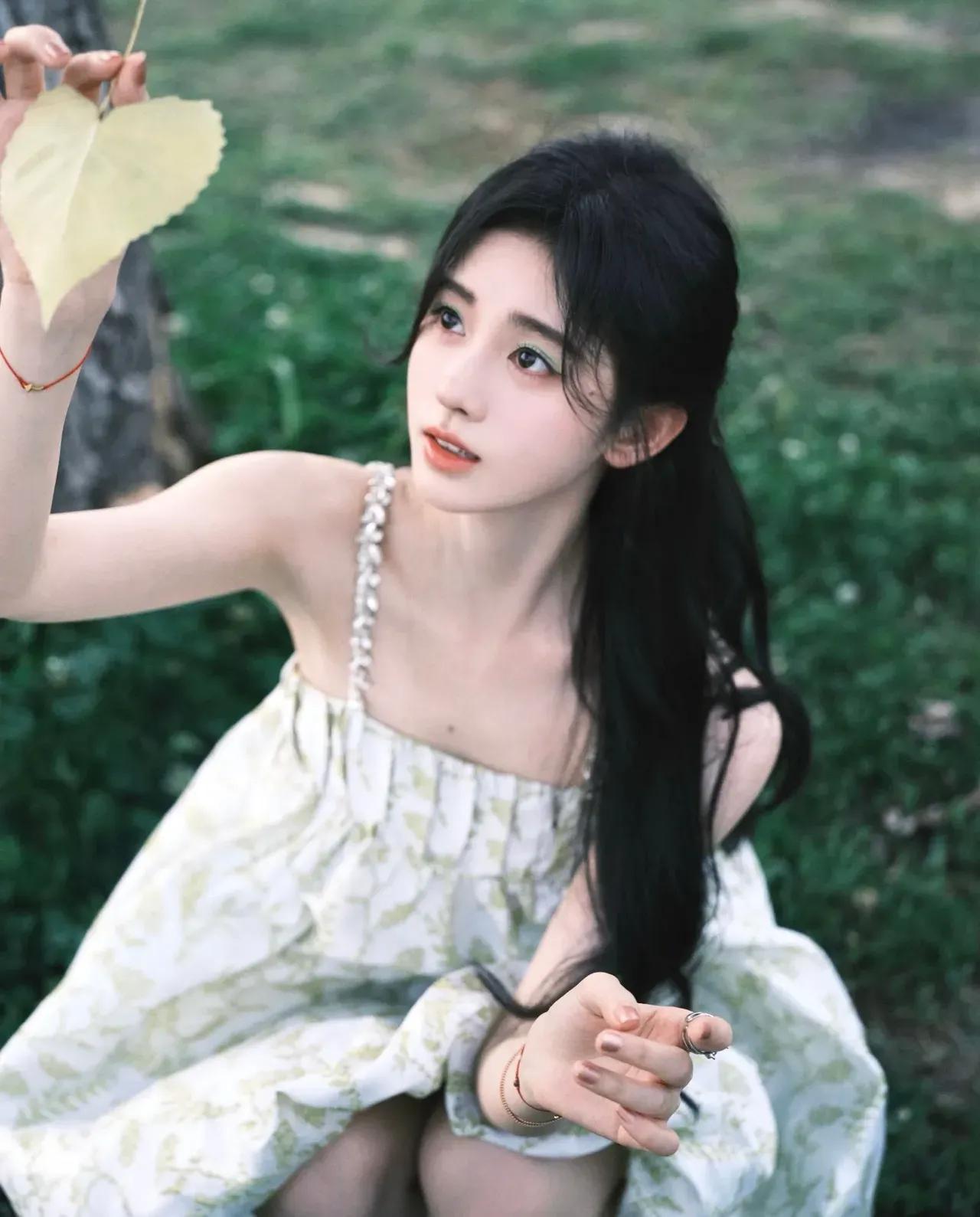 Ju Jingyi has long curly hair and a green floral suspender skirt. The ...