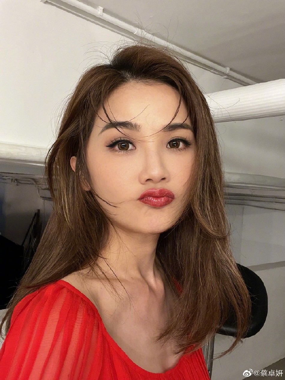 Cai Zhuoyan is wearing a red dress, her eyes are low and her smile is ...