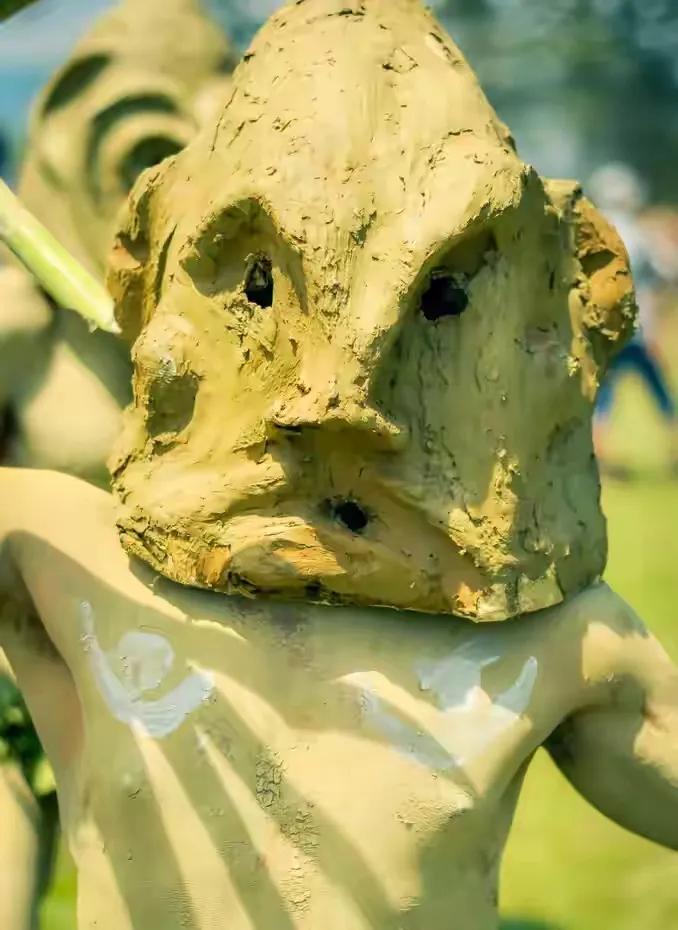 Fantastic clay figurine covered in leaves, covered in mud and with a ...