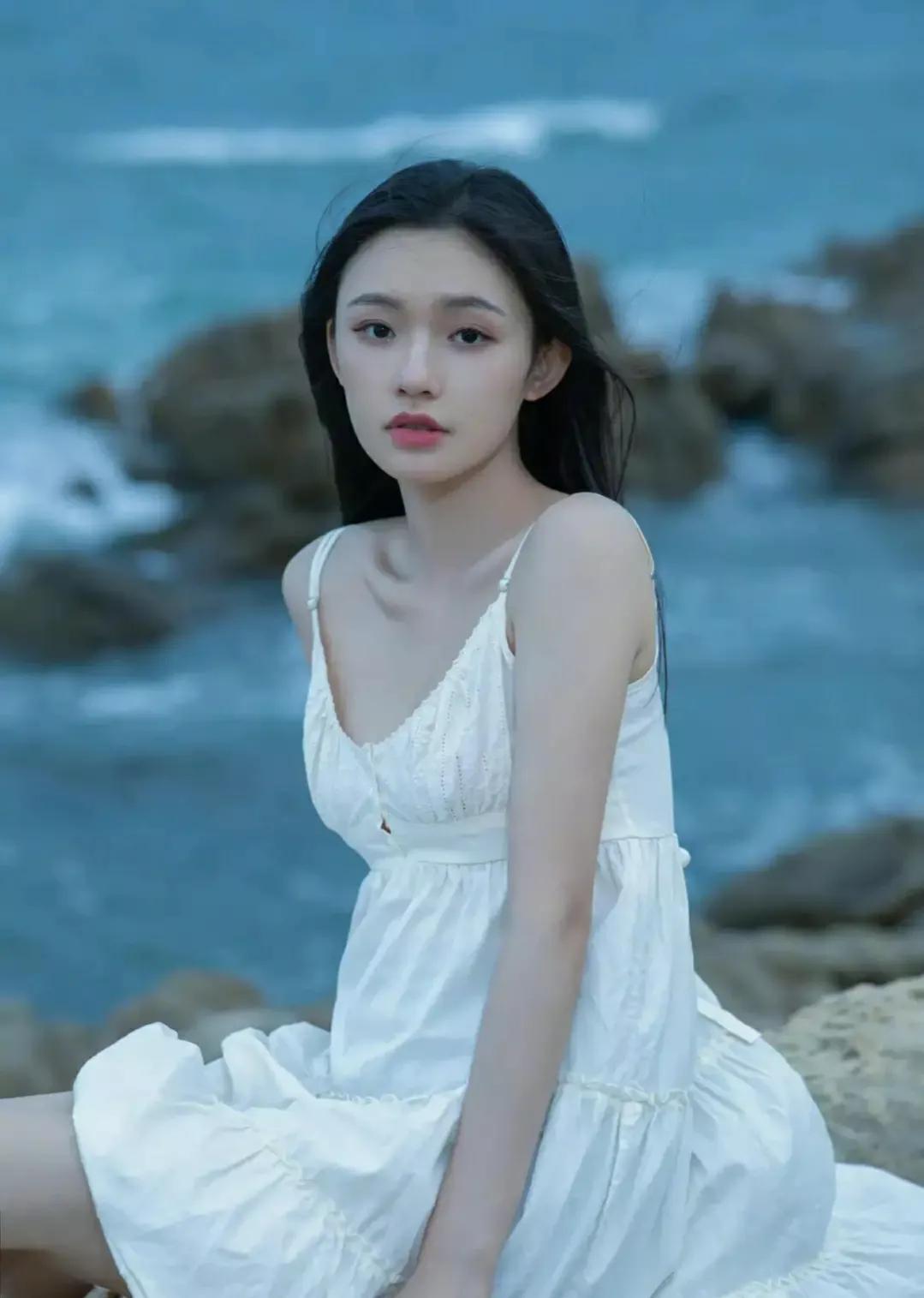 Lin Yun's beach photo by the sea, wearing a white dress with suspenders ...