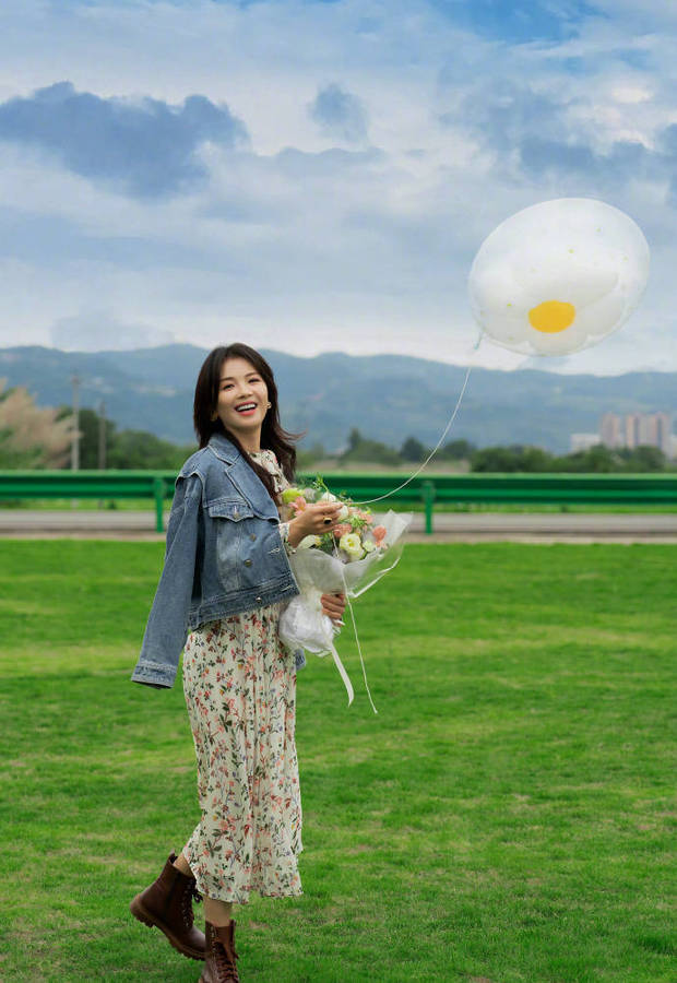 Liu Tao wears a floral skirt and a denim jacket with a gentle, generous ...