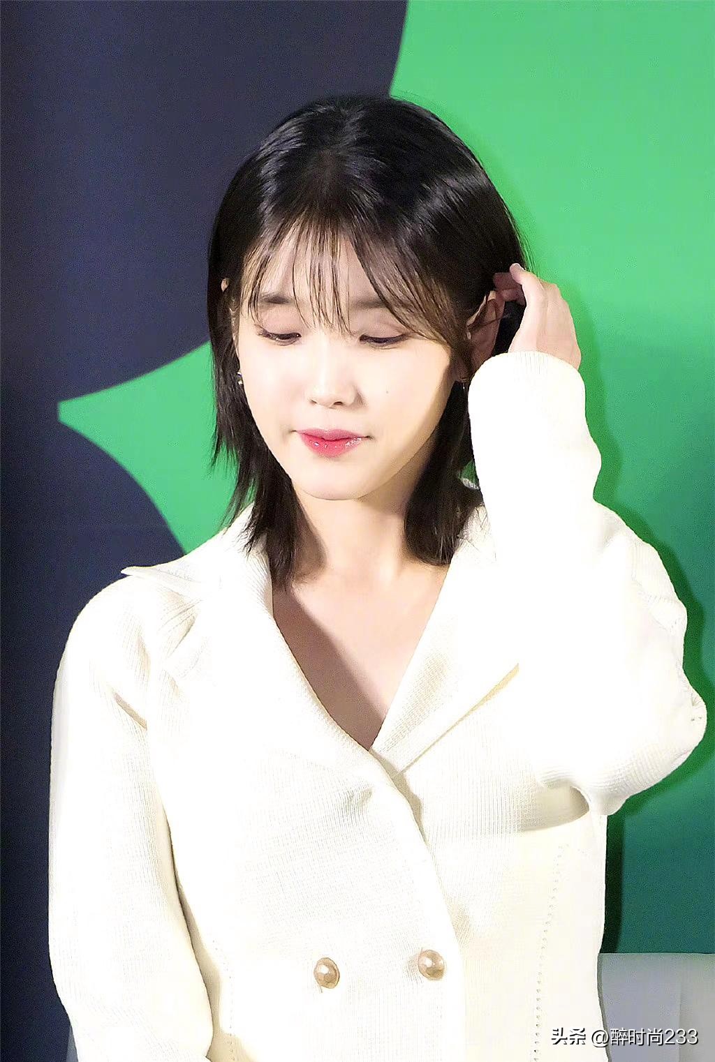 IU attended the press conference, dressed in a white suit with short ...