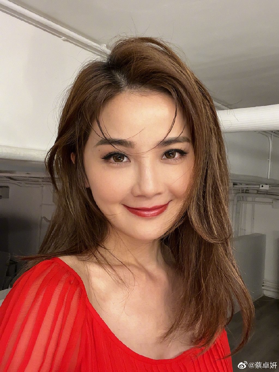 Cai Zhuoyan is wearing a red dress, her eyes are low and her smile is ...