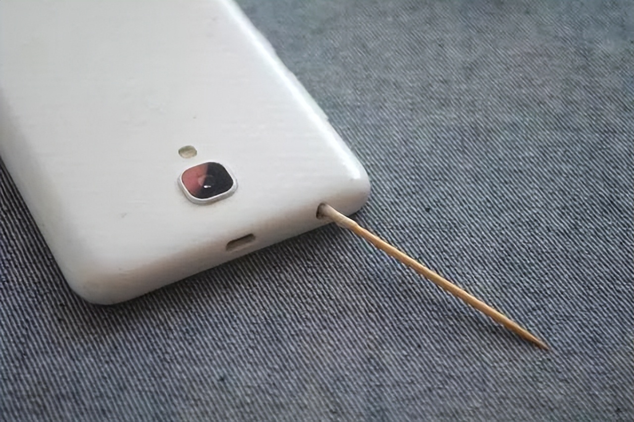 Inserting a toothpick into the charging port of the mobile phone is ...
