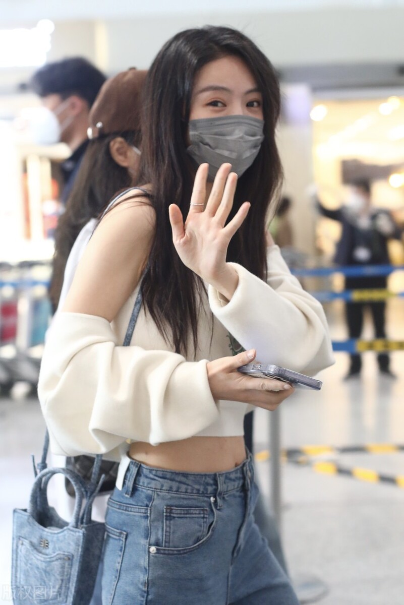 Cai Wenjing waved to fans at the airport wearing a tube top and jacket ...