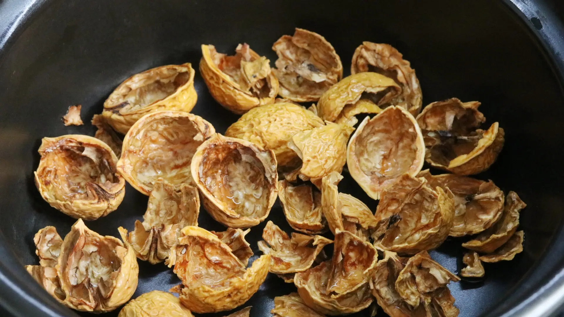 The walnut shell is fried in a pot, and it becomes delicious in an ...