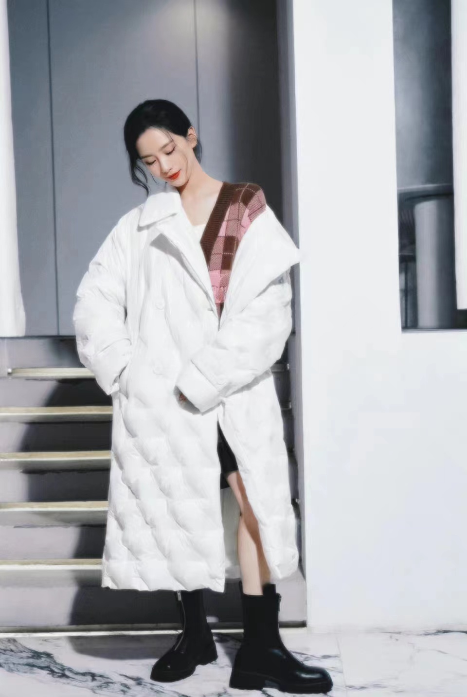 Liu Shishi wears a white long down jacket with a plaid cardigan and a ...