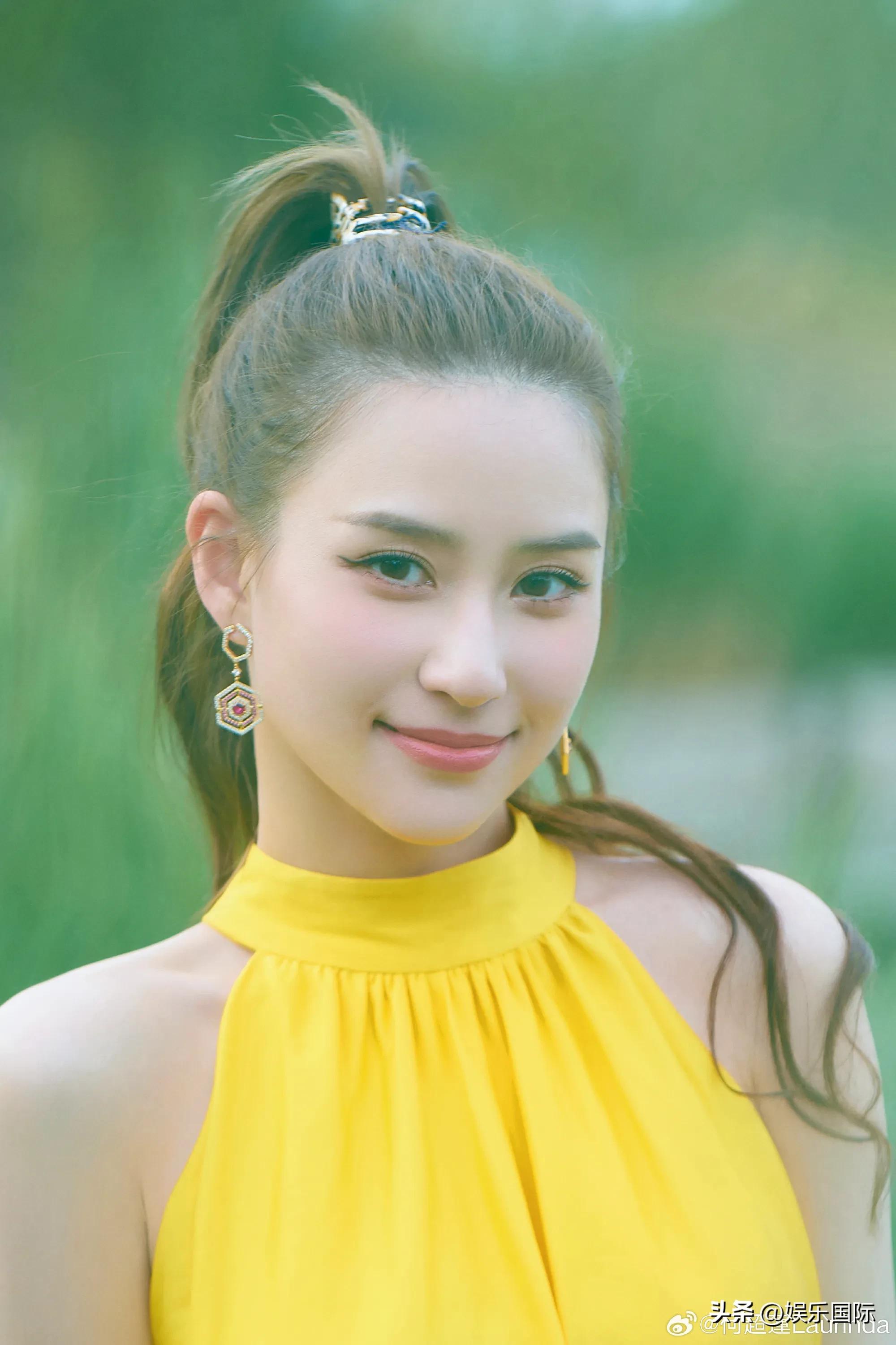 He Chaolian wears a yellow dress with a high ponytail and smiles ...