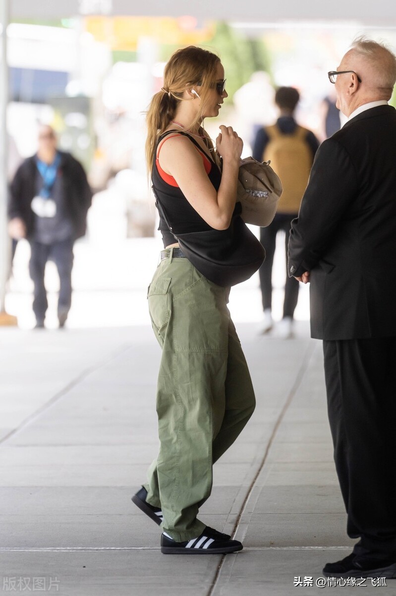 Jennifer Lawrence is wearing a black vest + army green overalls + black ...