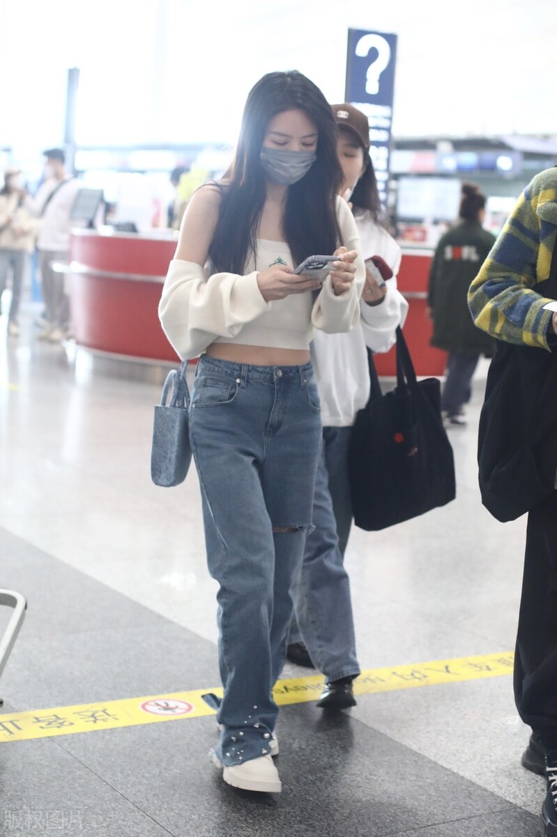 Cai Wenjing waved to fans at the airport wearing a tube top and jacket ...