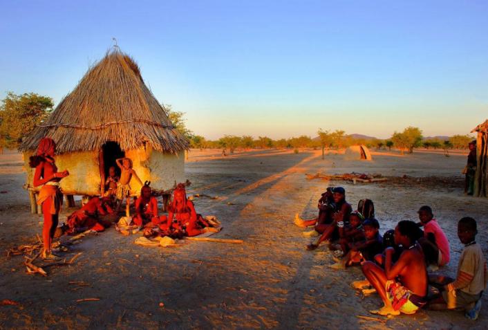 African red mud tribe, women smear red mud on their bare upper bodies ...