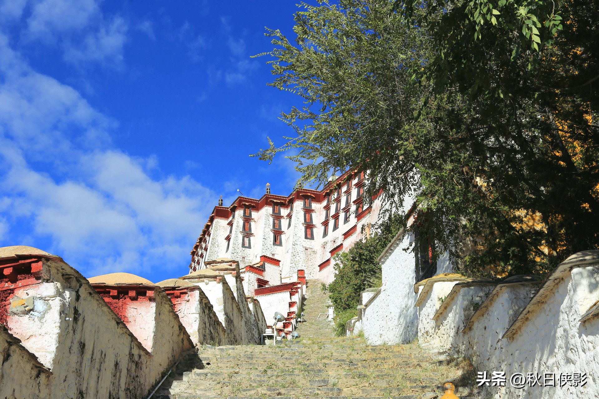 The October sun shines on the white walls of the Potala Palace, the top ...