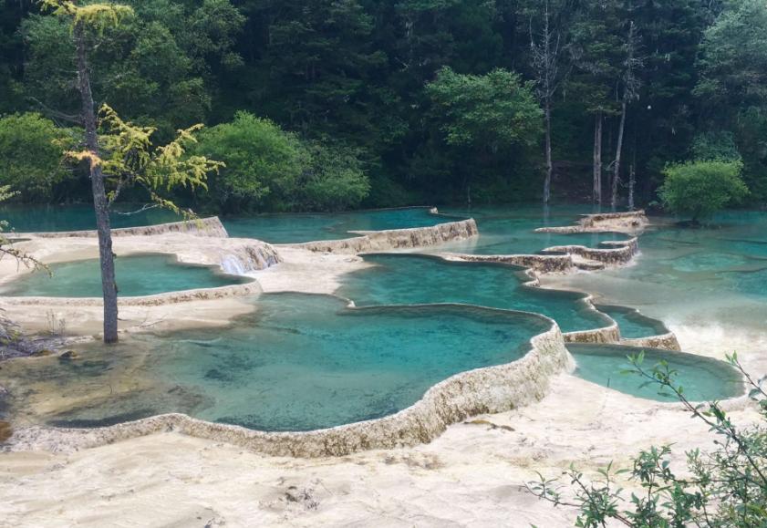 Tourists in Jiuzhaigou climb over the fence and step on the calcified ...