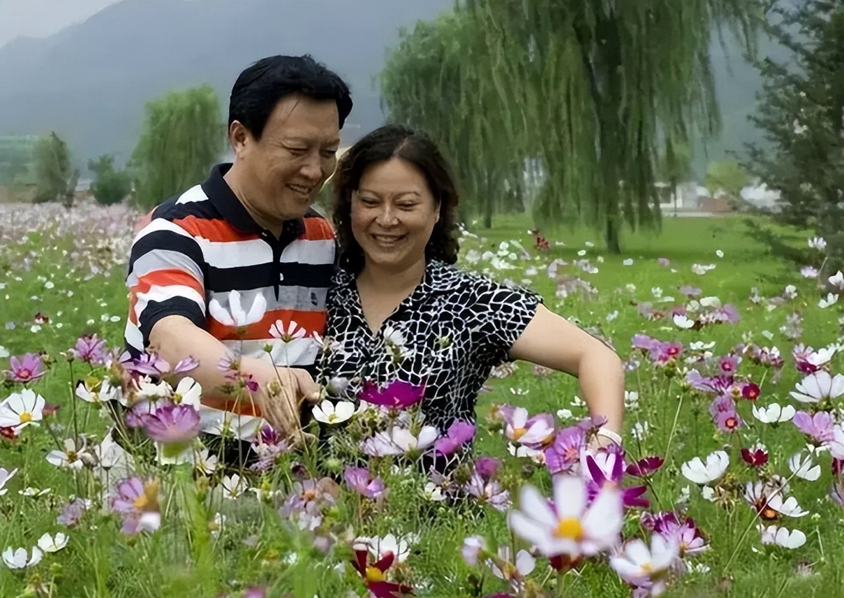 Tang Guoqiang rarely poses with his wife in the flowers, dressed very plainly, like an ordinary ...