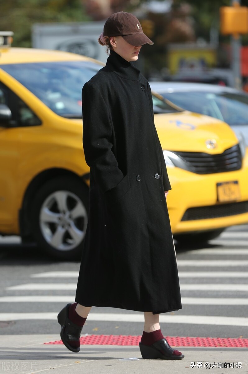 Emma Stone is wearing a black suit coat + wine red socks + baseball cap ...