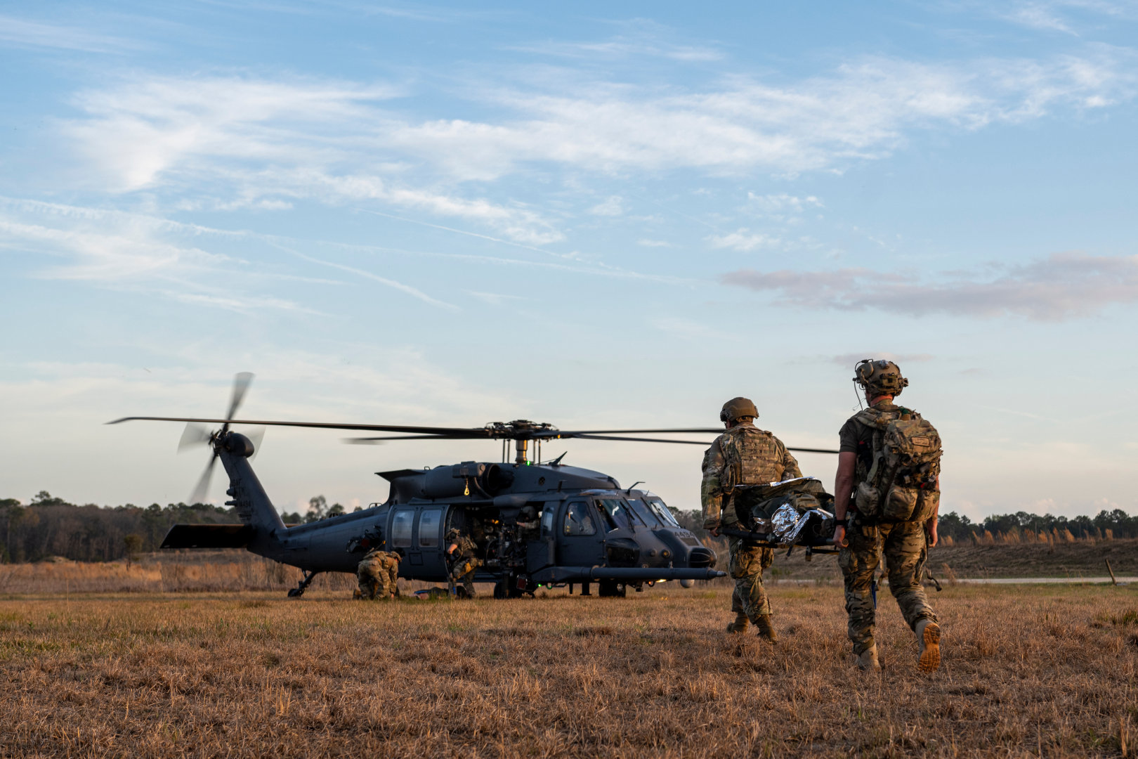 U.S. Air Force paratroopers lift a patient to a helicopter for ...