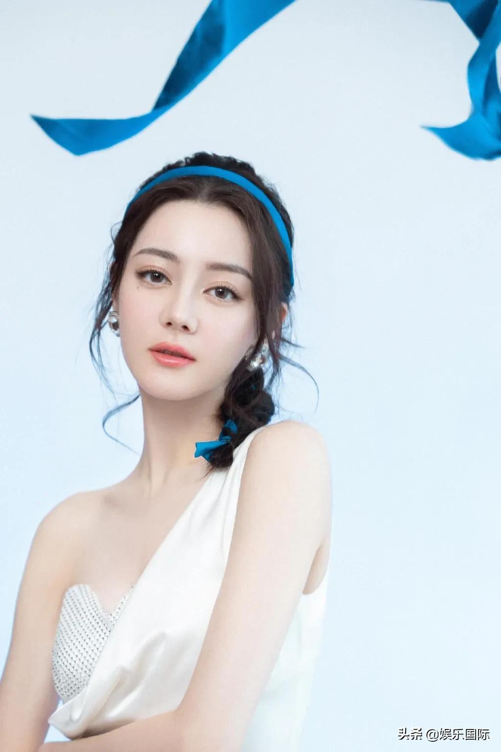 Reba wears a long satin dress, showing off the shoulders and blue ...