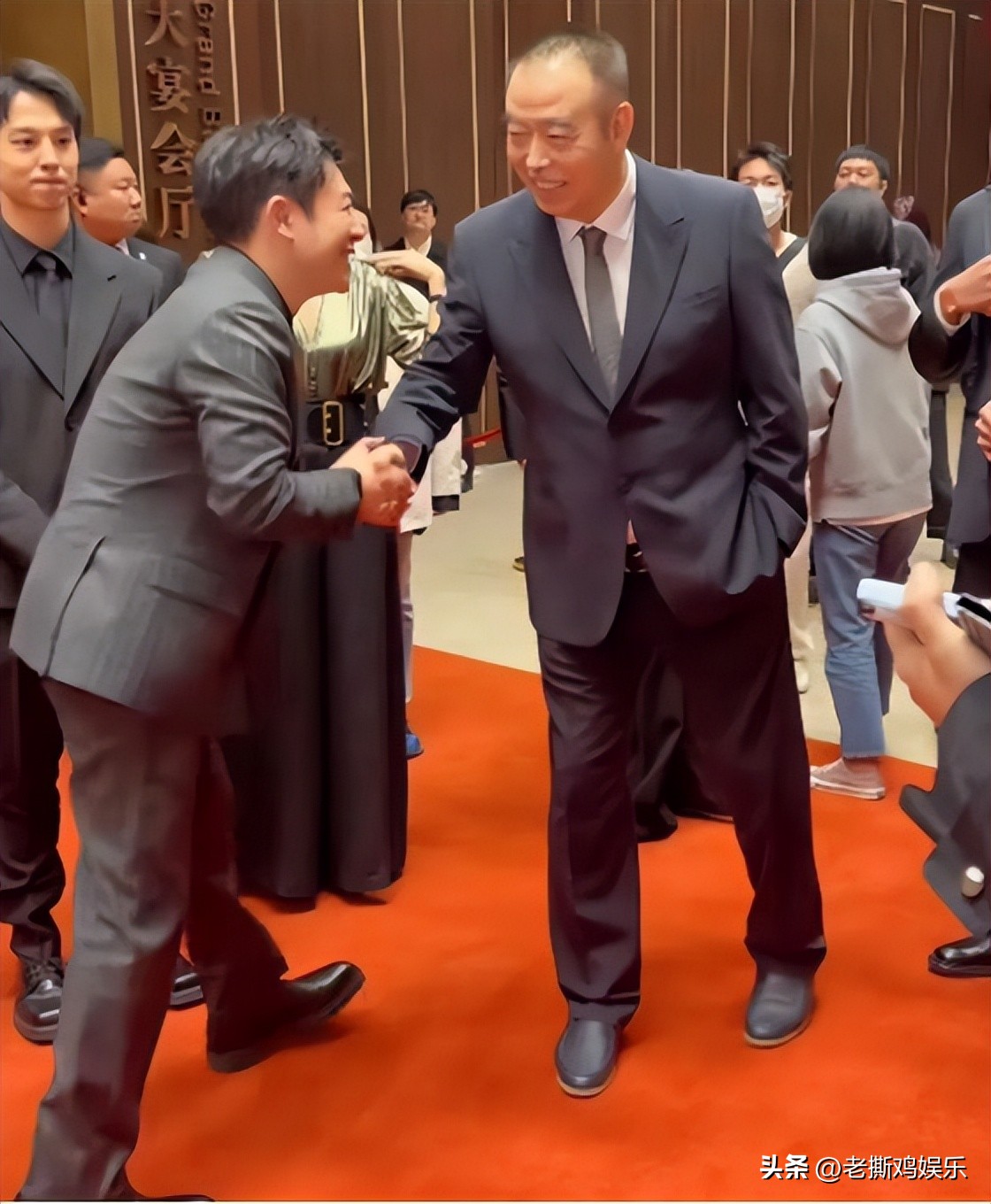 Director Chen Kaige shakes hands with Zhang Songwen with one hand in ...