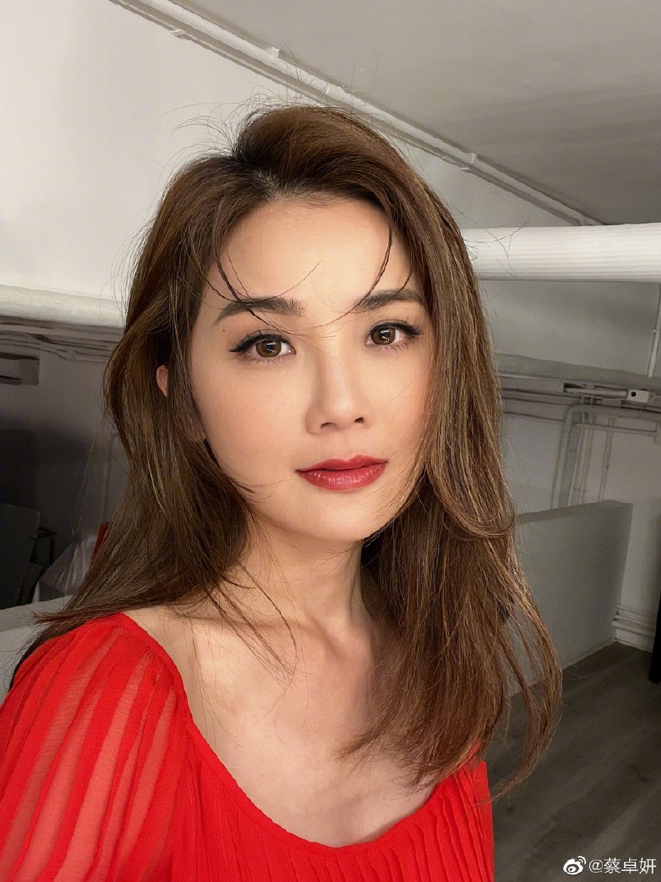 Cai Zhuoyan is wearing a red dress, her eyes are low and her smile is ...