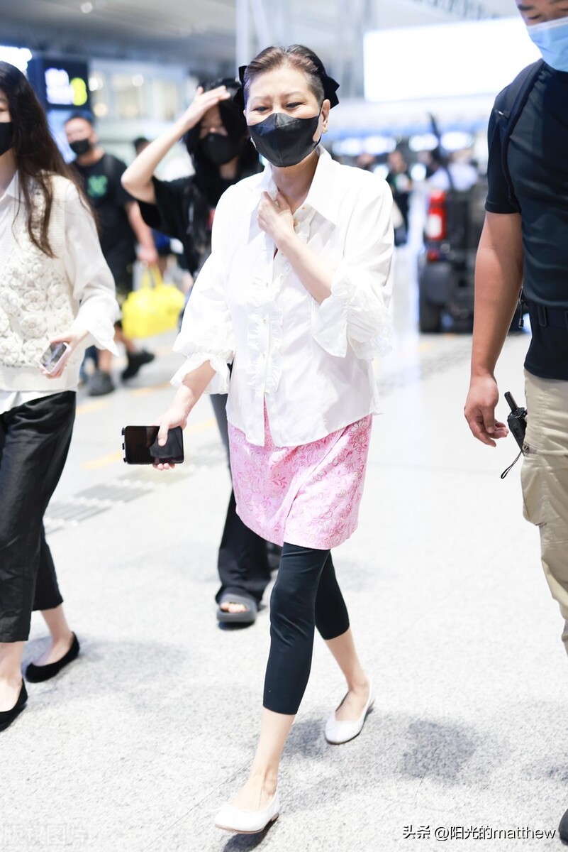 Zhang Qiang appeared at the airport in a white shirt and satin skirt ...