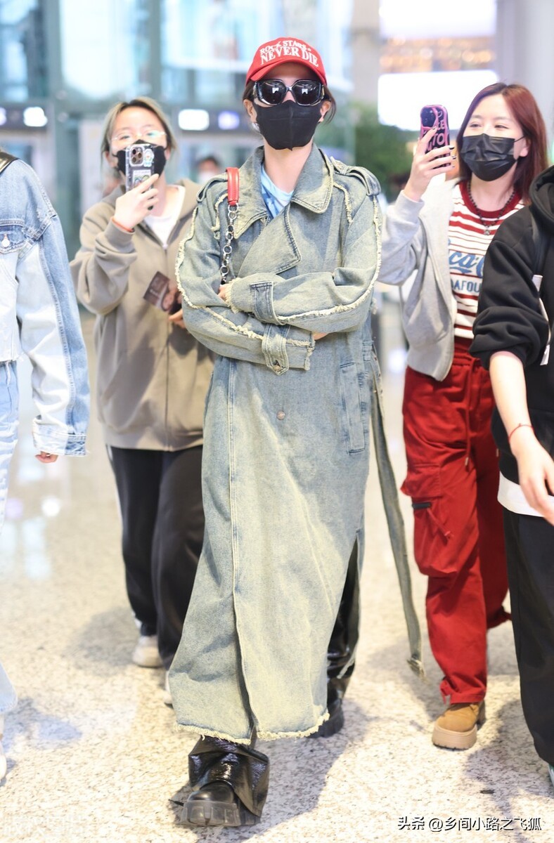 Xie Keyin is wearing a long denim trench coat + a red baseball cap ...