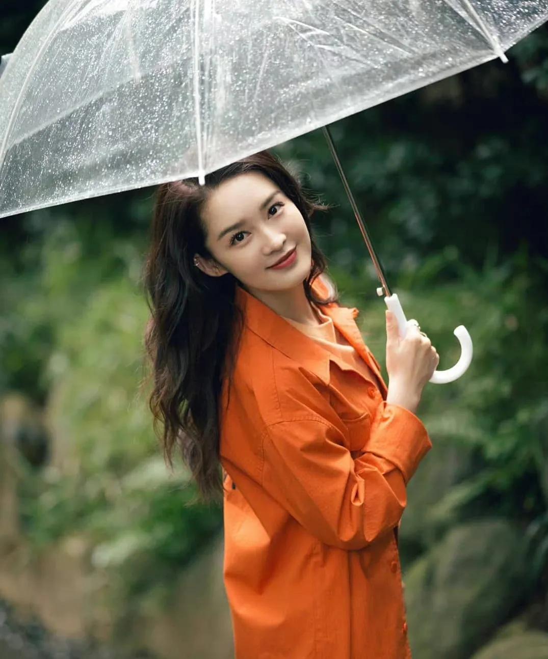 Li Qin held an umbrella in the rain and strolled in the forest ...