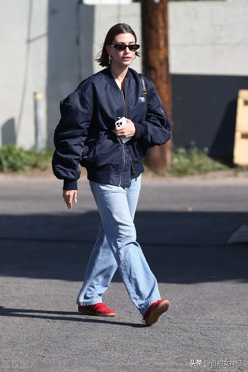 Hailey Bieber is wearing a dark blue flight jacket + denim wide-leg ...