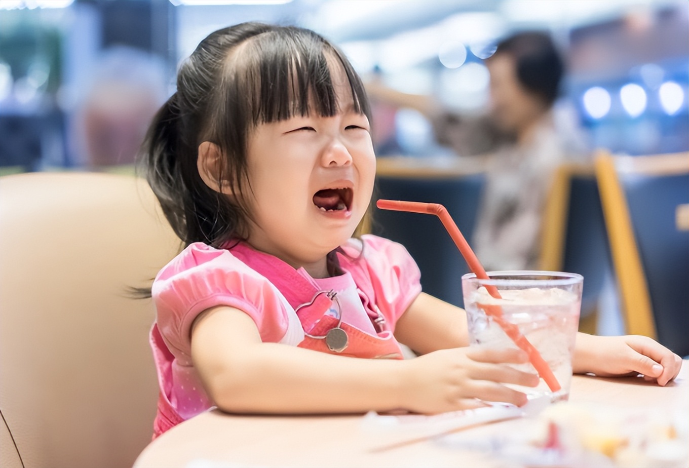 The child is crying and rolling in the shopping mall, the mother has a ...
