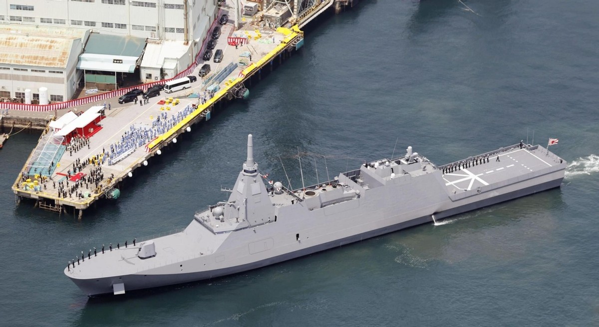 With a stick on his head, Japan looks down on the new frigate, and its ...