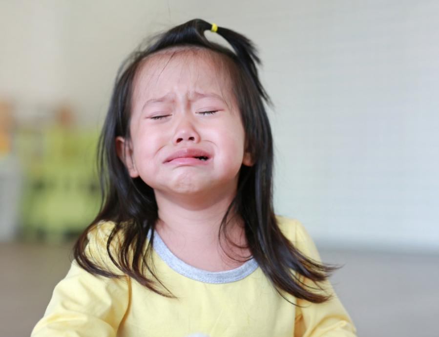 The child is crying and rolling in the shopping mall, the mother has a ...