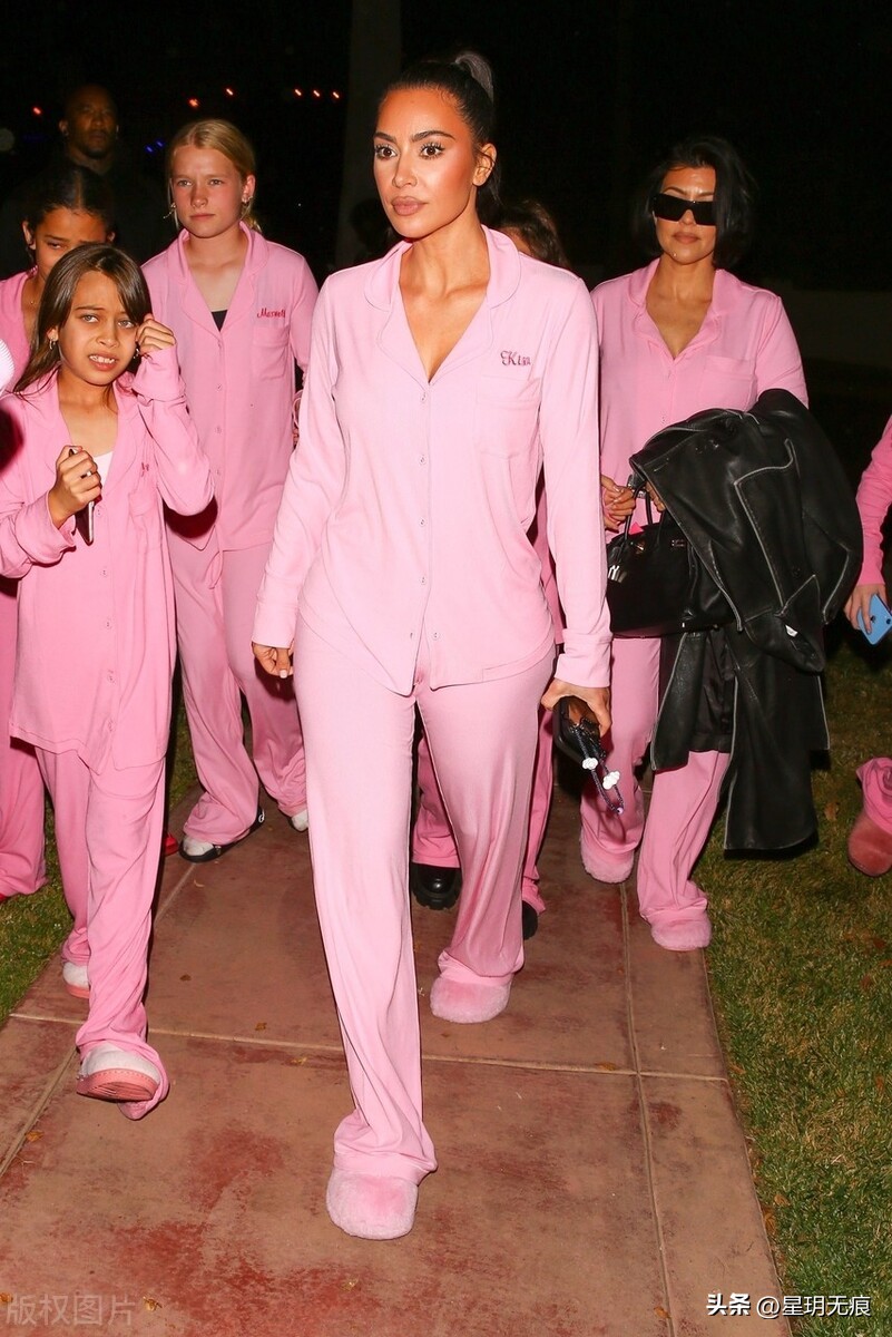Kim Kardashian is wearing a pink pajamas suit + pink plush slippers ...
