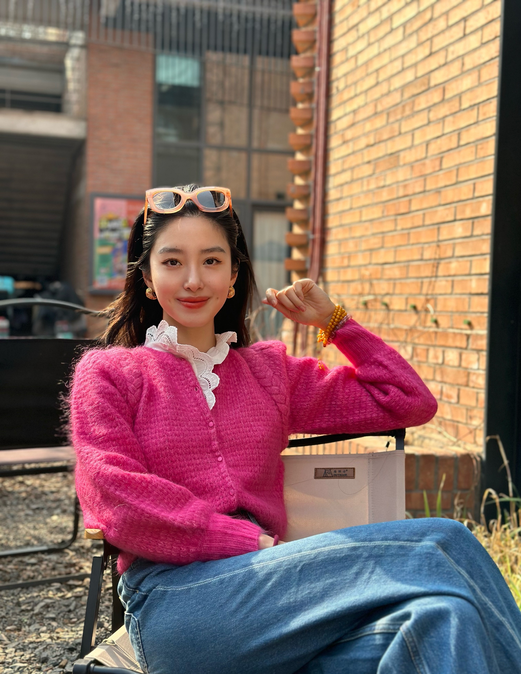 Actress Yang Caiyu is wearing a pink sweater and blue jeans, showing a ...