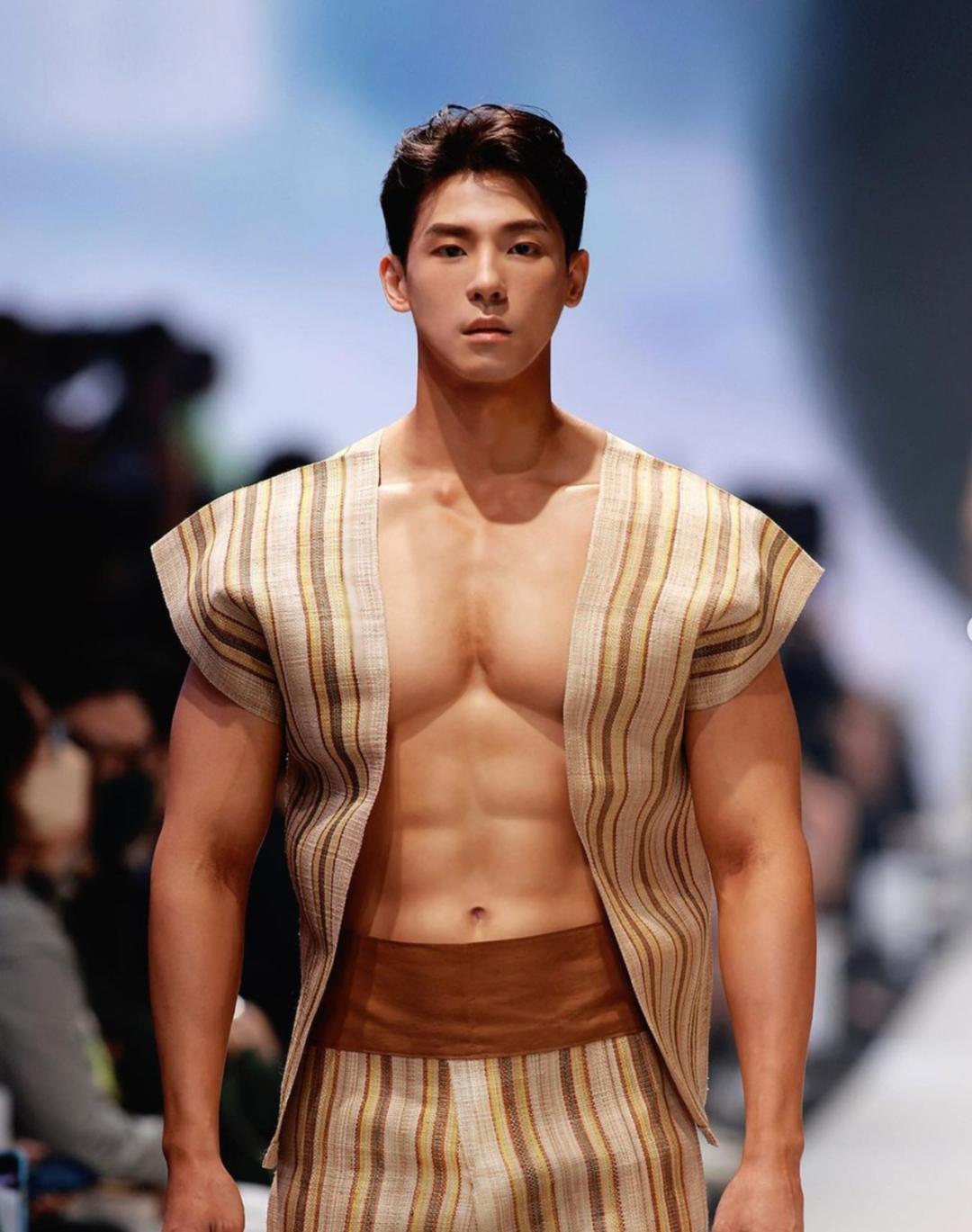 The muscular male model wearing single trousers on the catwalk is ...